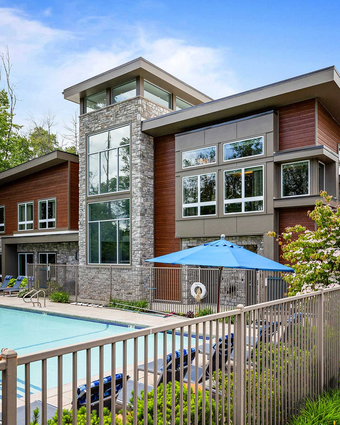 Outdoor pool deck with sun tanning beds and umbrellas