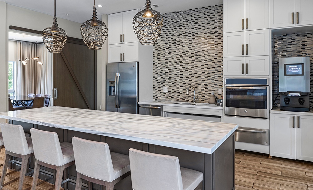 A luxury apartment clubhouse kitchen with white cabinetry